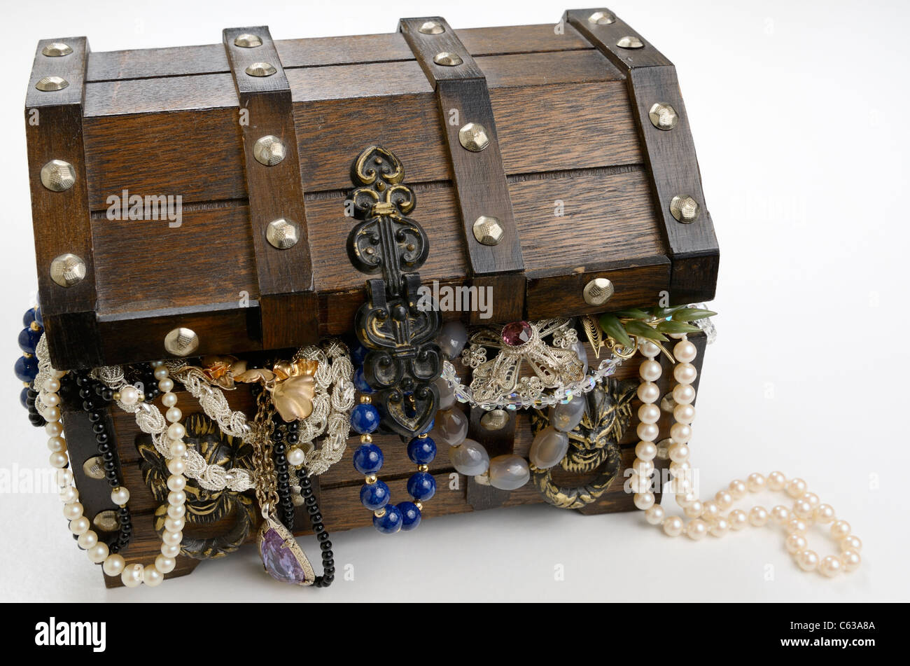 Treasure chest overflowing with riches of pearls and jewels on white ...