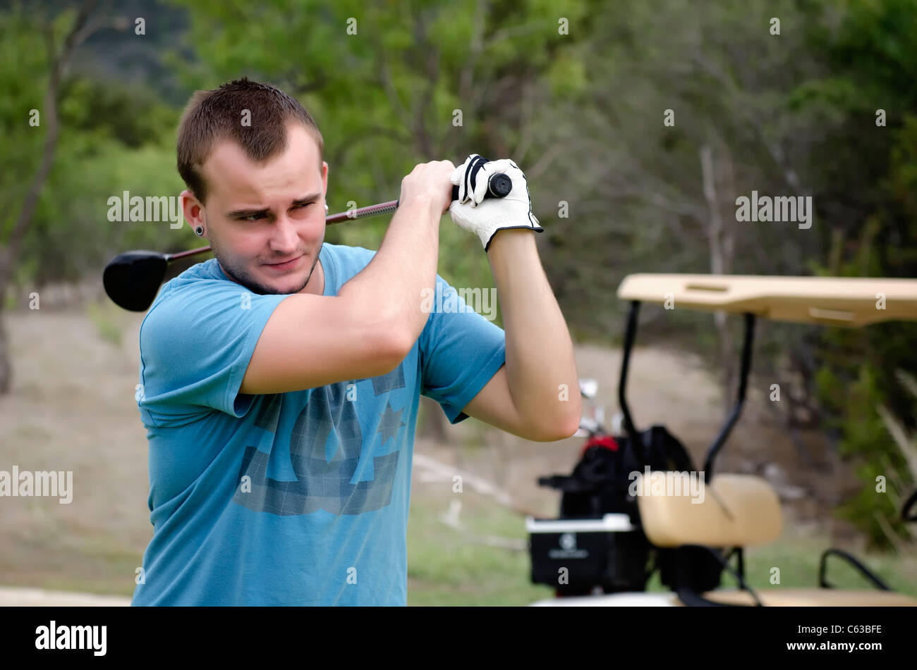 Young golfer hitting off Stock Photo - Alamy