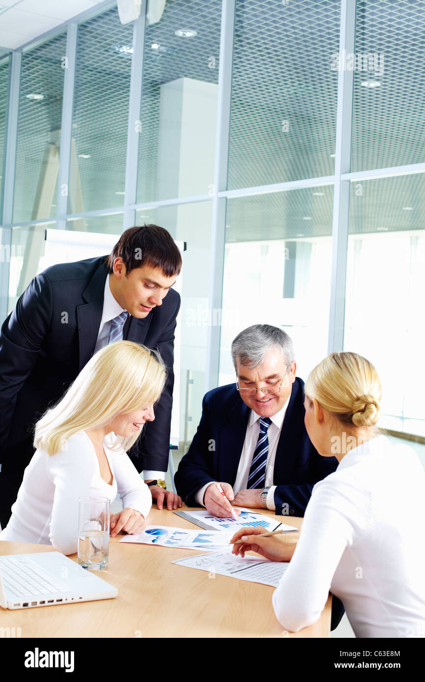 Business team of four people sitting and working together Stock Photo ...