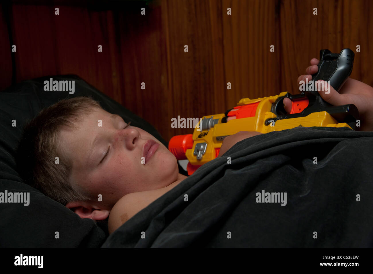 sleeping boy armed with toy gun Stock Photo - Alamy