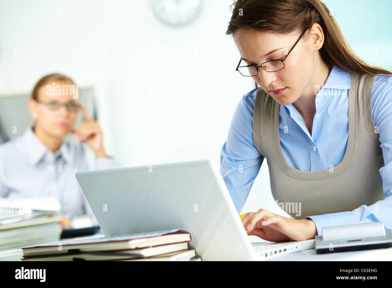 Portrait of pretty secretary typing in office Stock Photo - Alamy