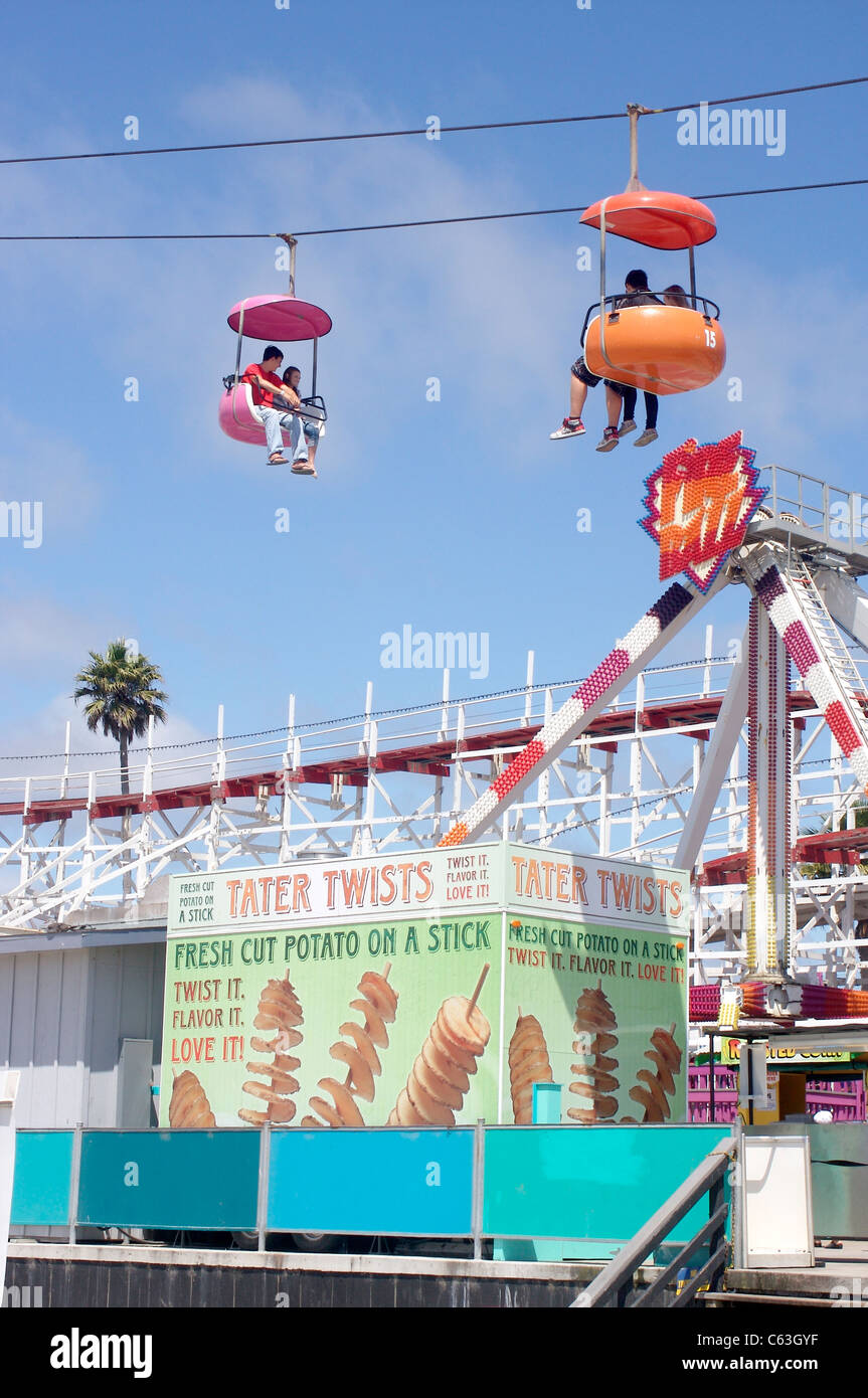 People on the Sky Glider elevated ride pass over the Santa Cruz Beach ...