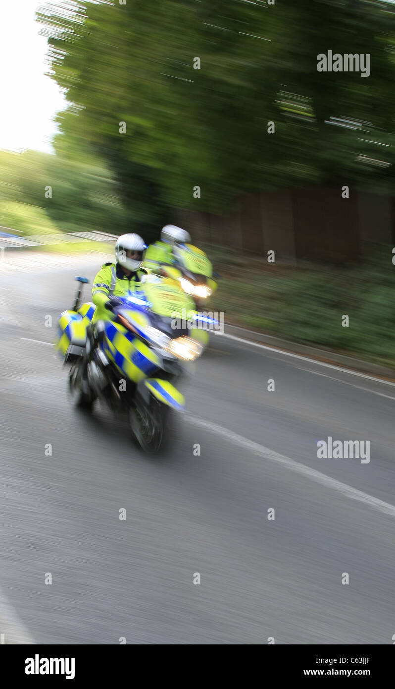 Police motor cyclists ride at speed through Surrey side roads UK Stock ...