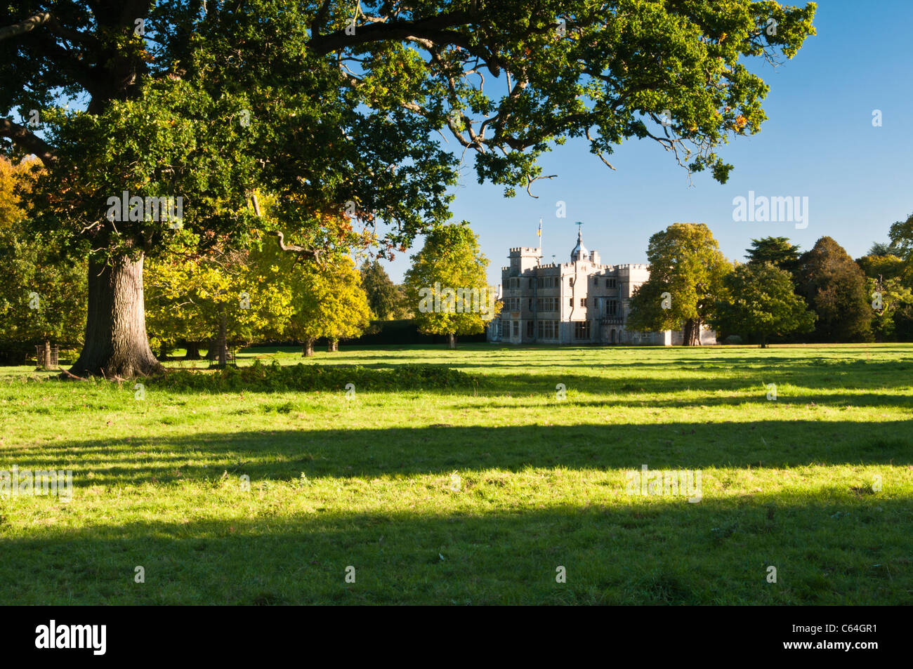 Rousham House viewed amongst mature native trees with long shadows cast ...