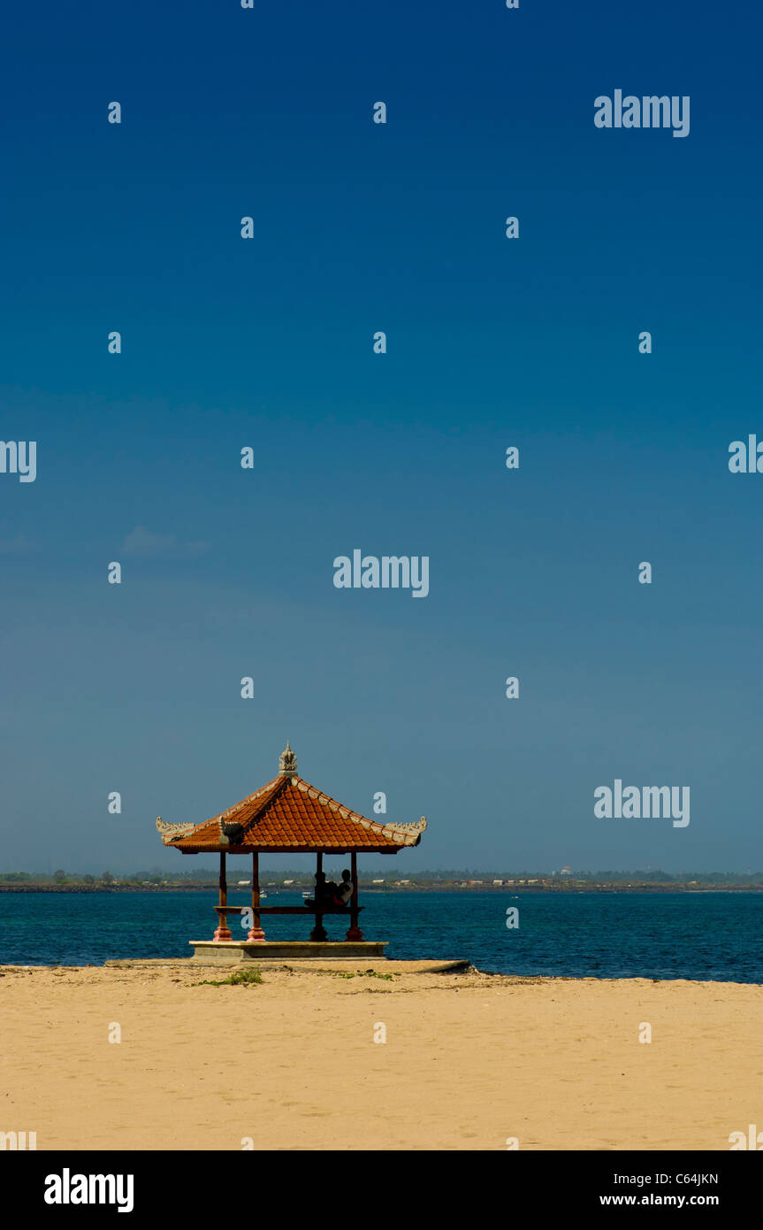 2 unidentifiable people sitting in a Balinese bale hut on Nusa Dua ...