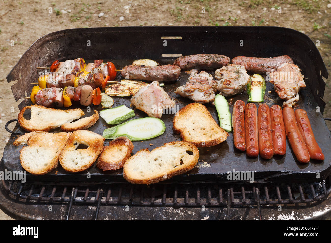 barbecue with meat, sausage, bread and vegetables Stock Photo - Alamy