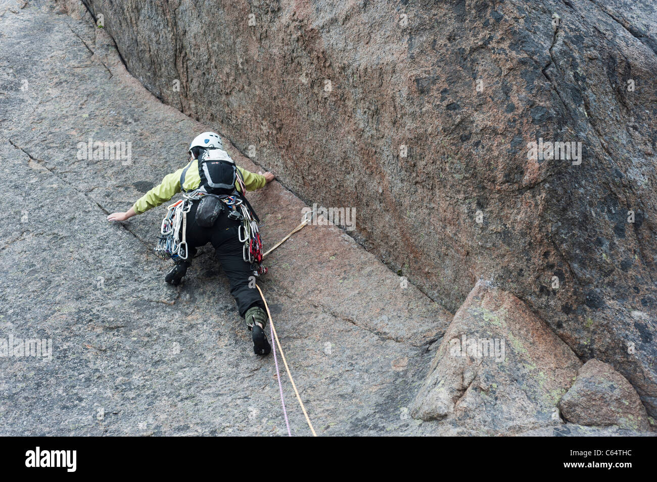 A female rock climber climbing in traditional style in Lofoten Islands ...