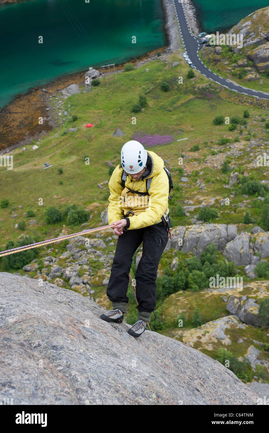 A female rock climber abseiling on Lofoten Islands, Norway Stock Photo ...