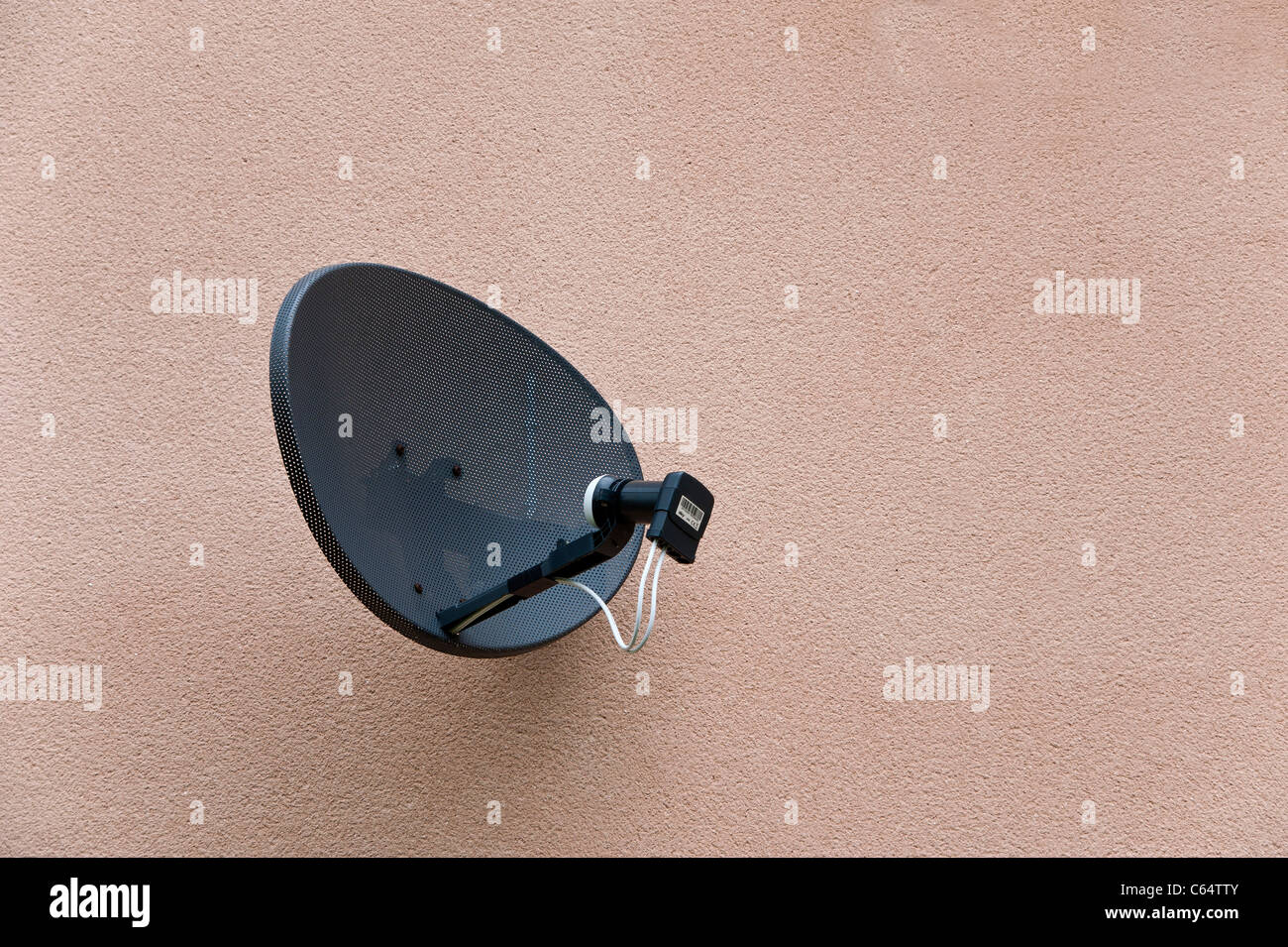 Satellite TV reception aerial (dish) mounted on the wall of a ...