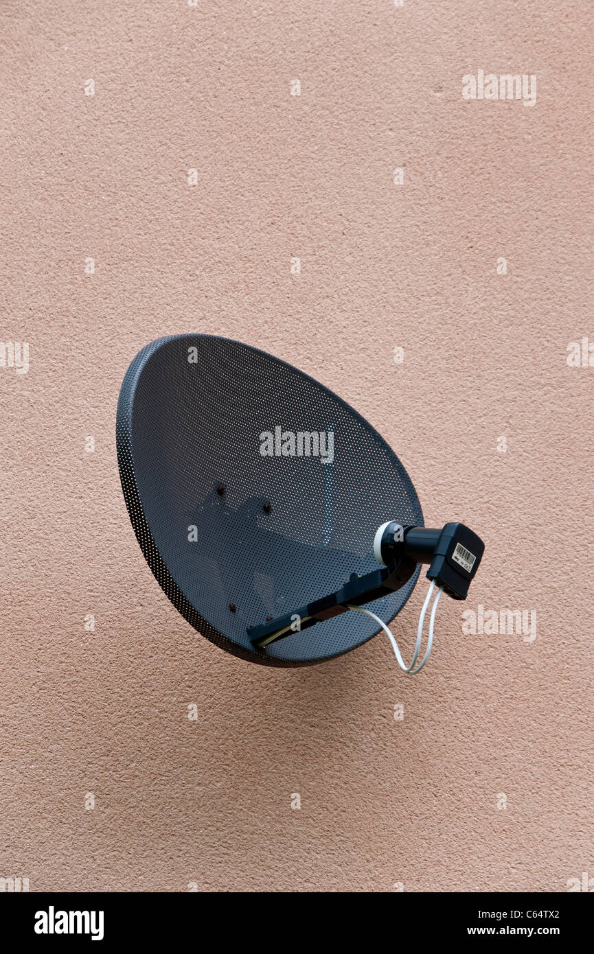 Satellite TV reception aerial (dish) mounted on the wall of a ...