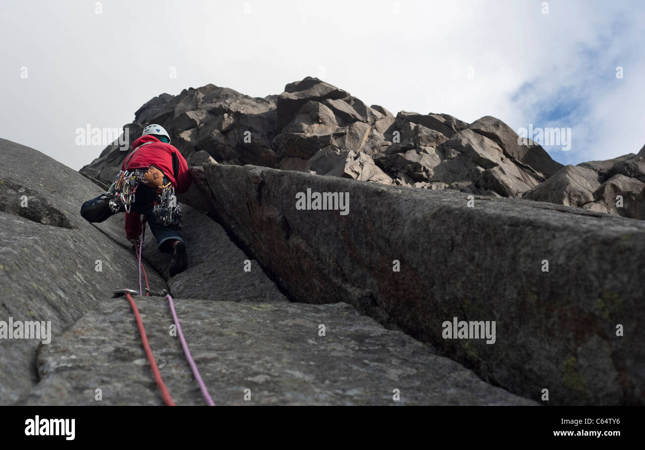 A male rock climber climbing in traditional style in Lofoten Islands ...