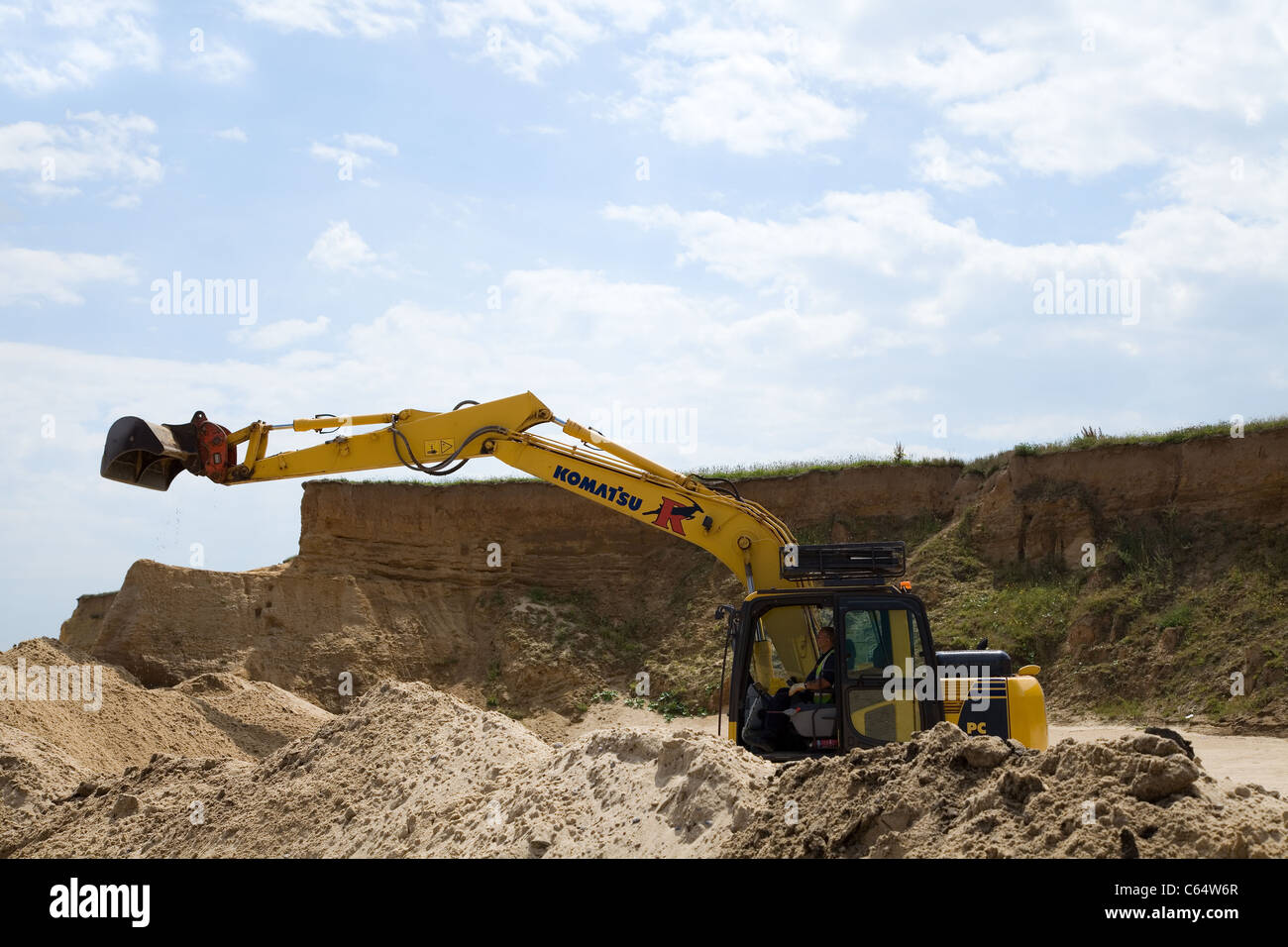 Komatsu PC130 seen here on a beach digging a trench for an ...
