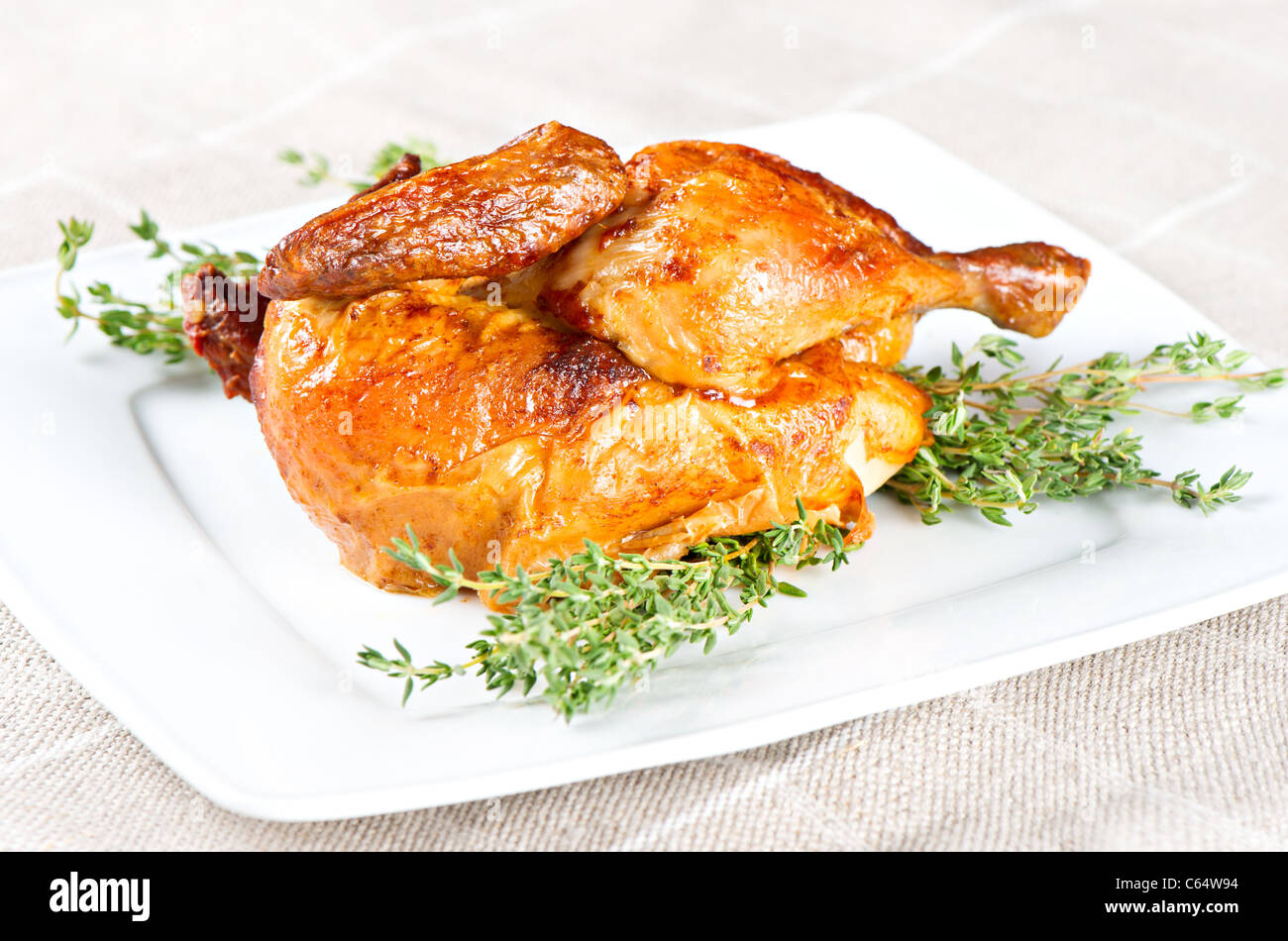 grilled chicken on a white plate with herbs Stock Photo - Alamy