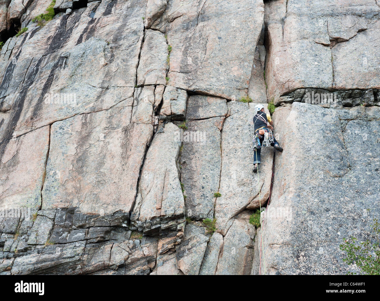 A male rock climber climbing in traditional style in Lofoten Islands ...
