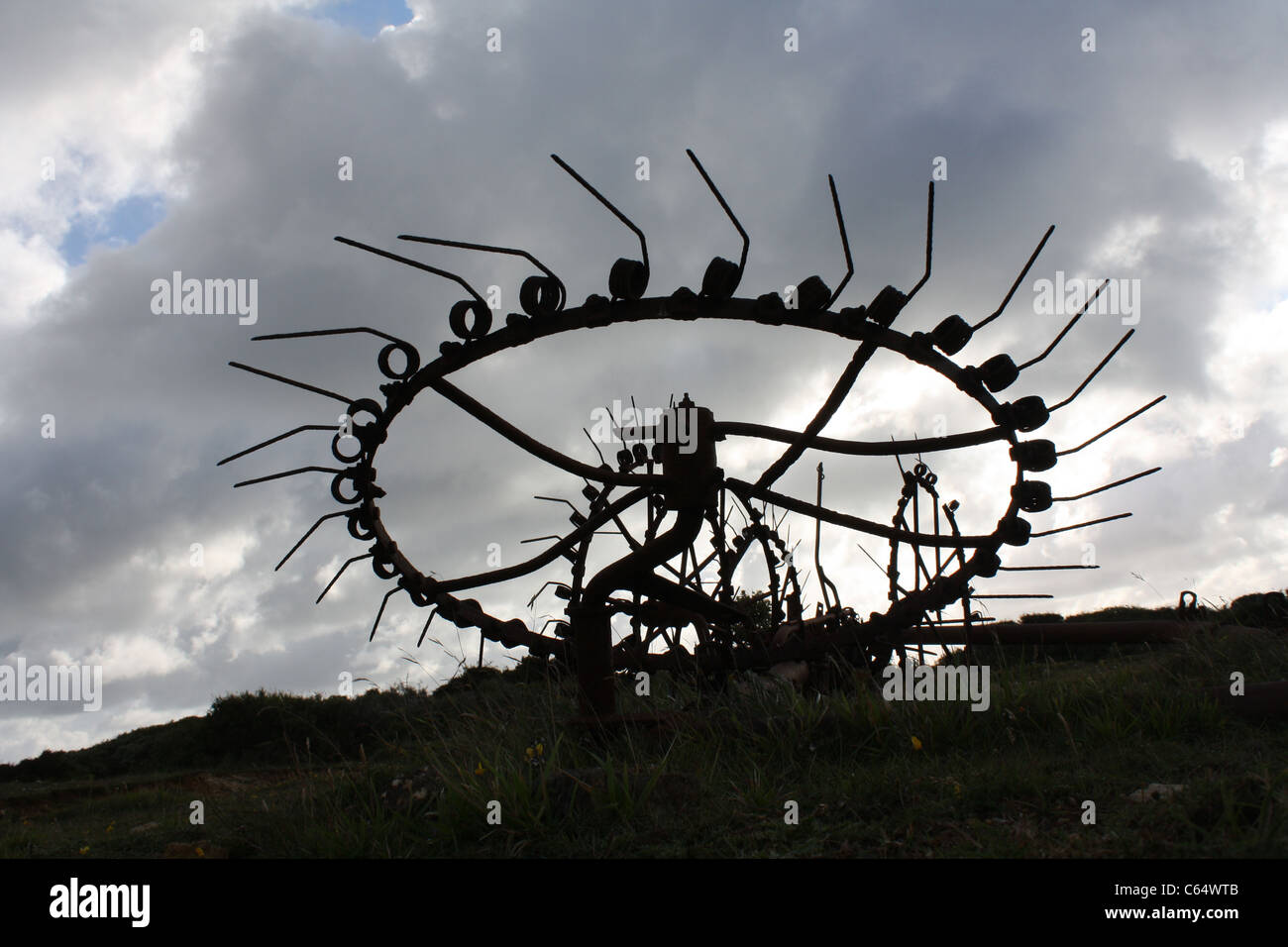 Old discarded farm machinery silhouetted against stormy sky Stock Photo ...