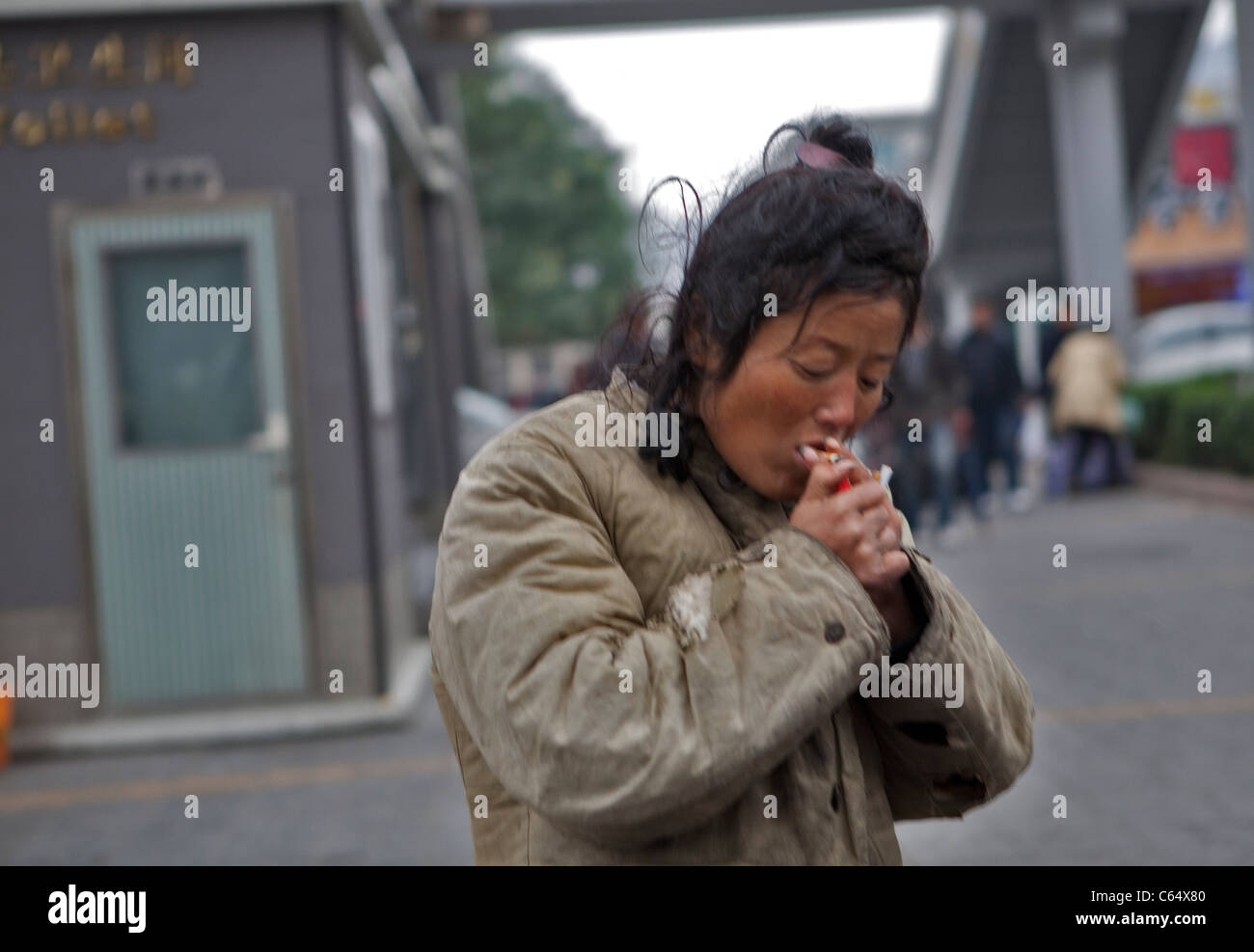 Poor woman lighting a cigarette on the street of Beijing Stock Photo ...