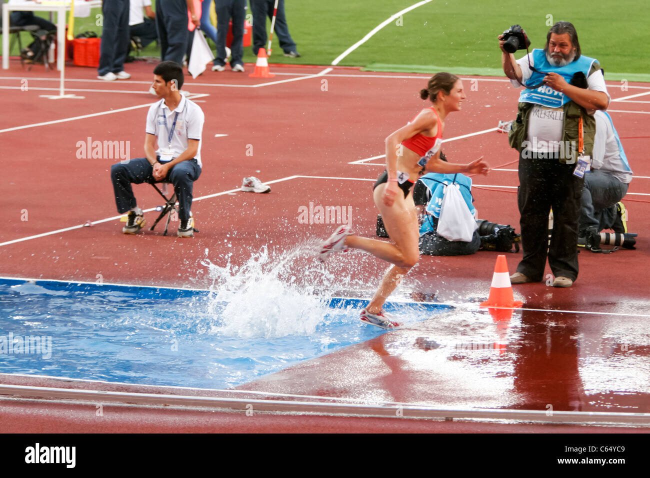 Athlete female runner and photographer in action at athletic race of ...
