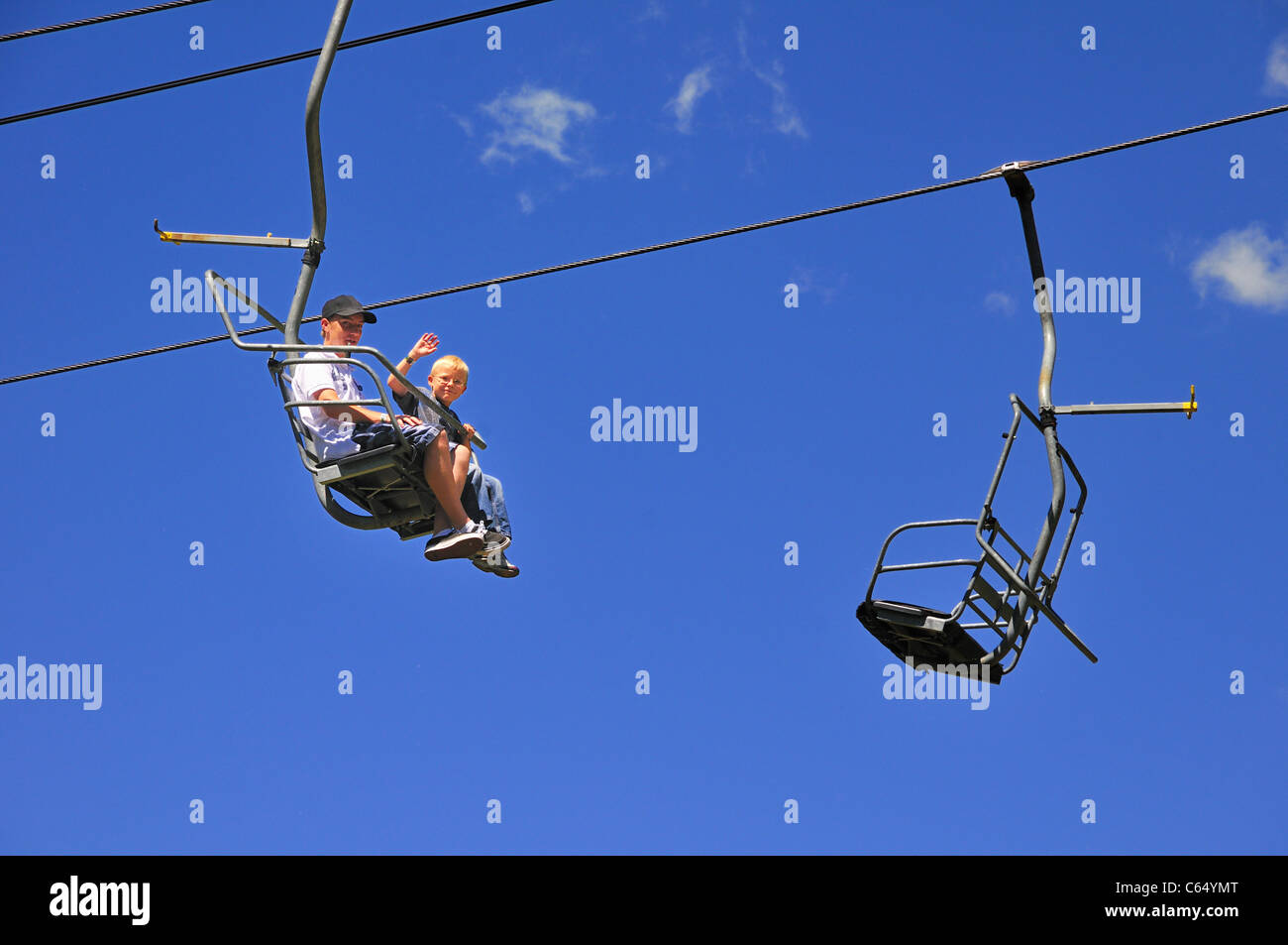 A father and son ride the Chickadee ski lift at Snowbird Ski and Summer ...