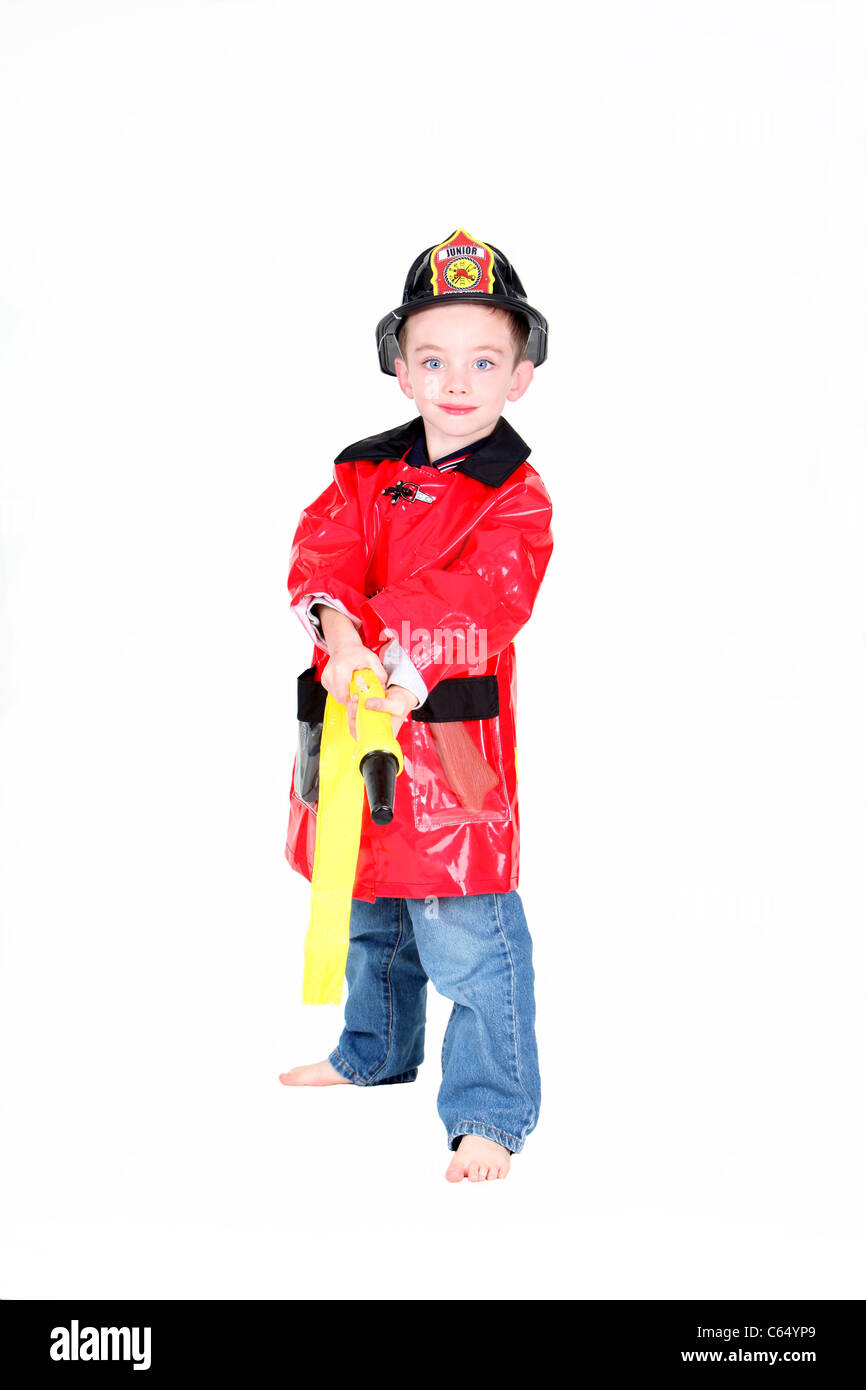 Preschool age boy in fireman costume with hose on white background ...