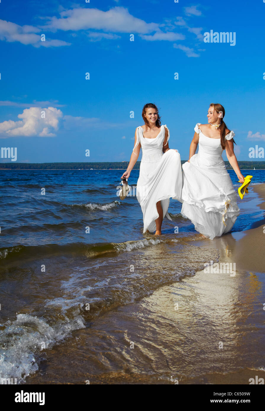 two beautiful slavonic brides walking along coastal strip Stock Photo ...