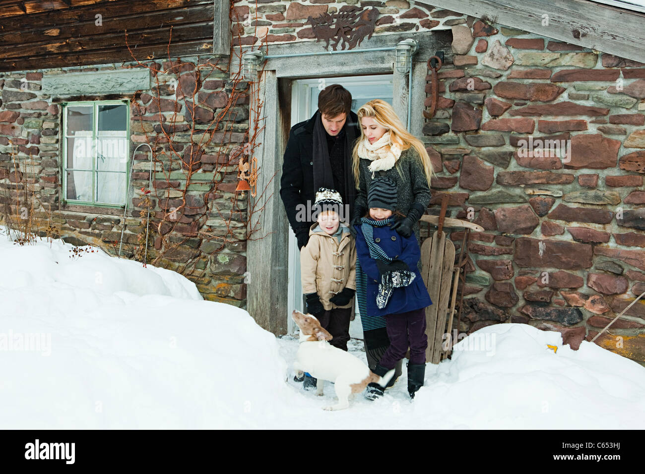 Family outside rustic house in snow Stock Photo - Alamy
