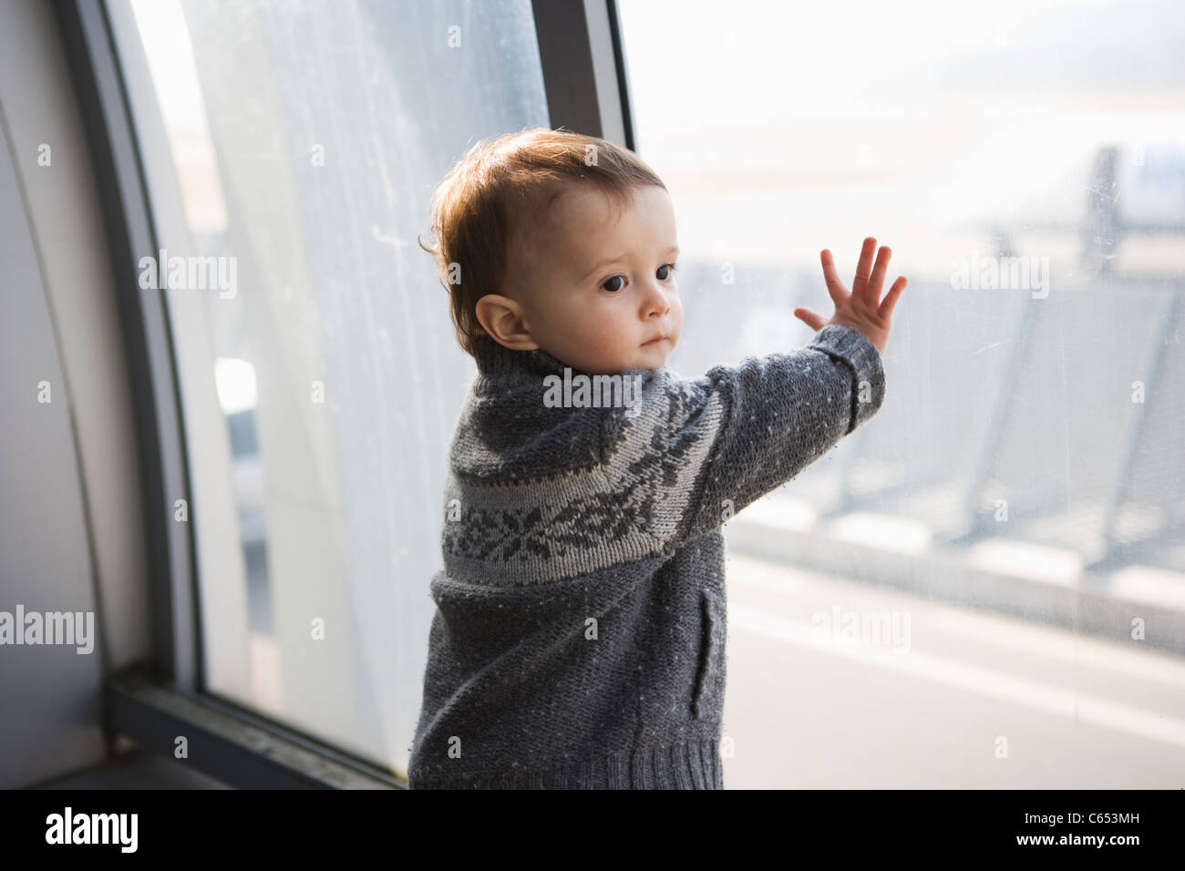 Boy touching airport window Stock Photo - Alamy