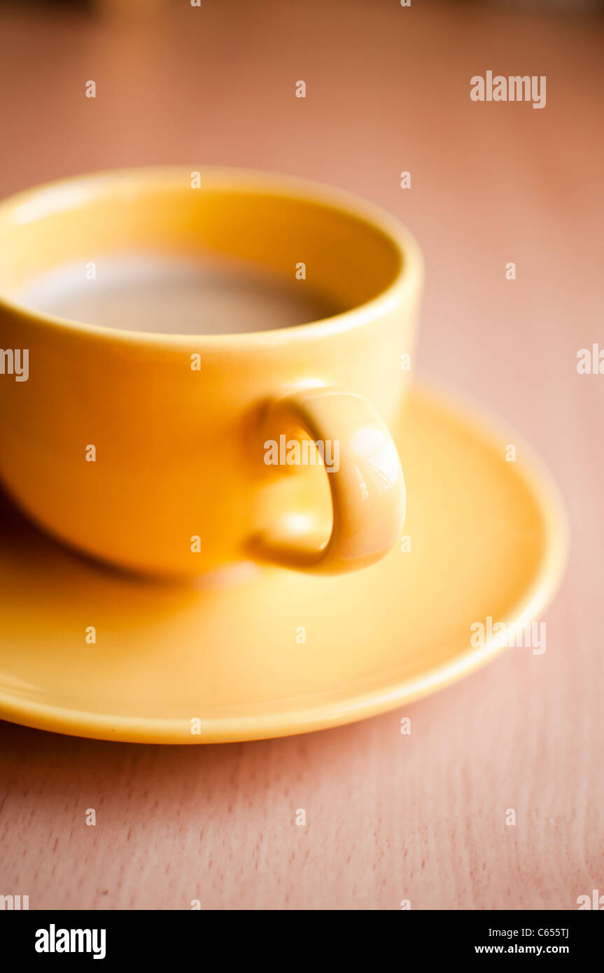 Coffee in an yellow cup Stock Photo - Alamy