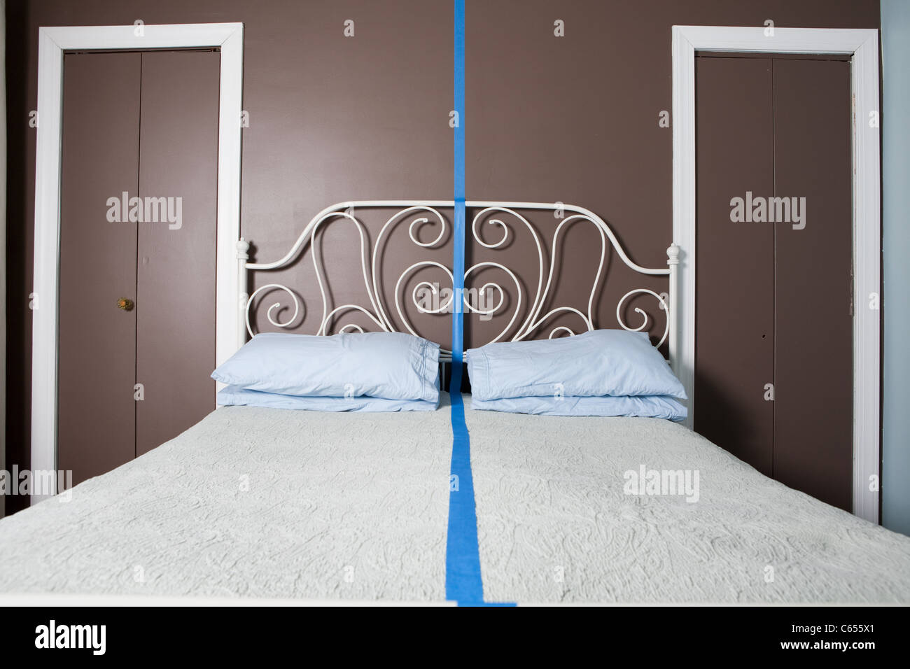Double bed separated by blue line Stock Photo - Alamy
