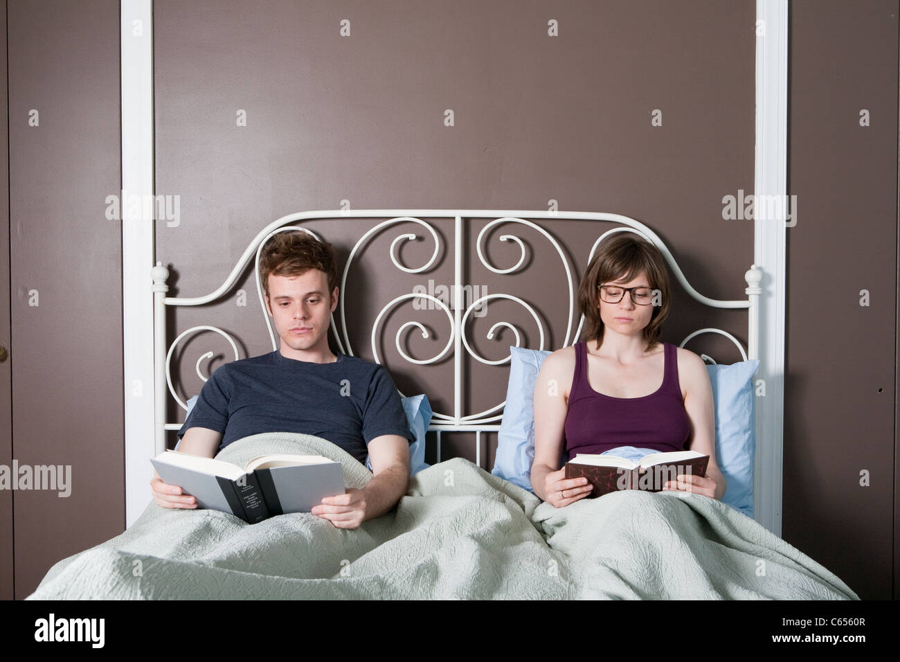 Young couple reading in bed Stock Photo - Alamy