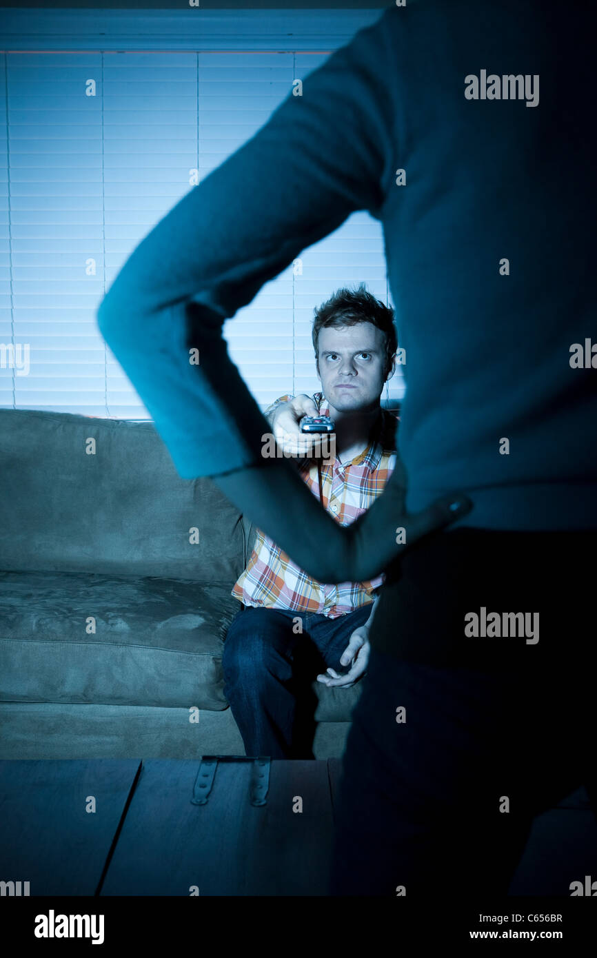 Young man watching tv, woman blocking view Stock Photo - Alamy