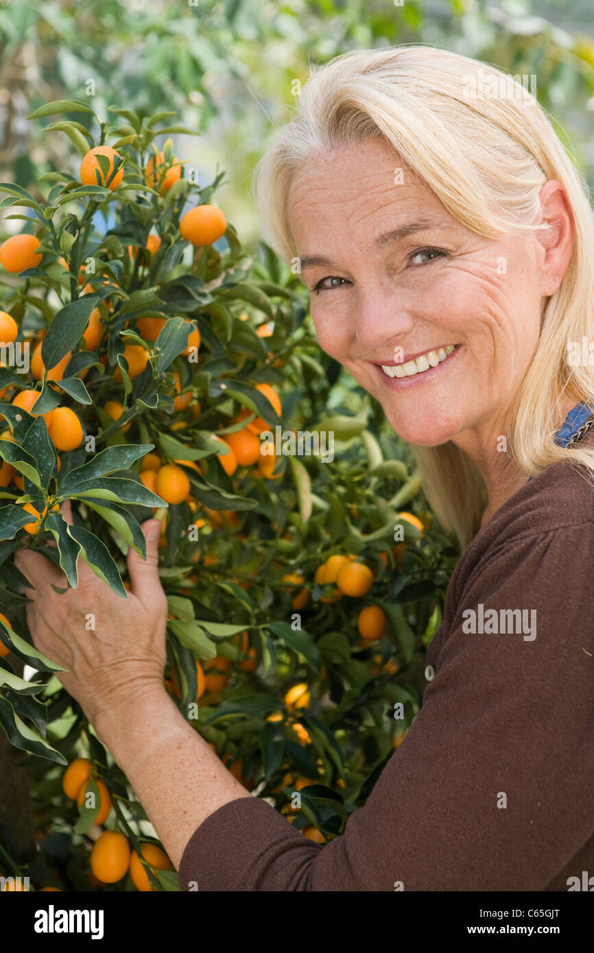 Mature woman by fruit tree Stock Photo - Alamy