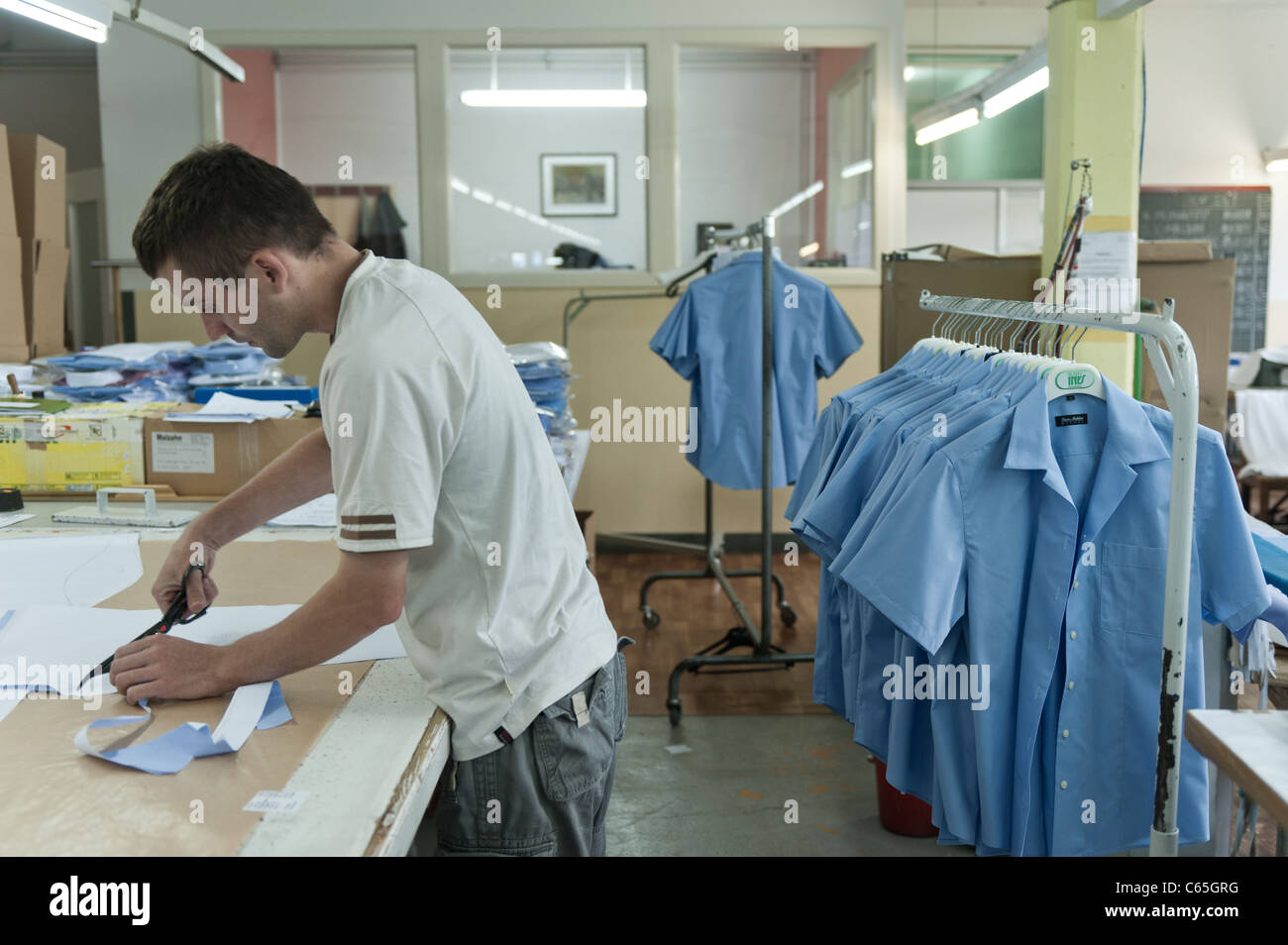 A worker cutting patterns for shirts in factory in central Bosnian town ...
