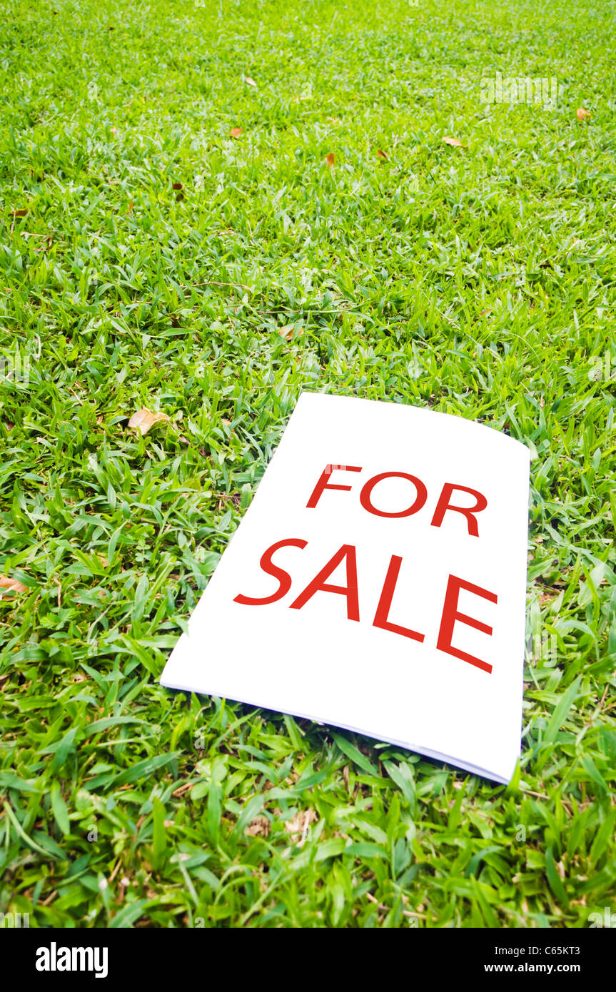 a for sale sign on grass field. For real estate background Stock Photo ...