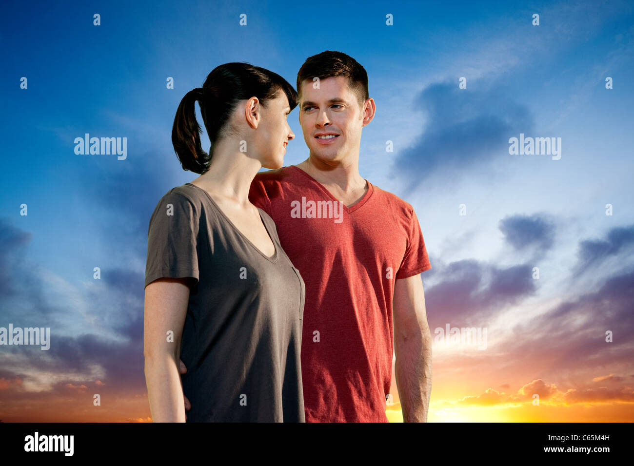 Couple against dramatic sunset Stock Photo - Alamy