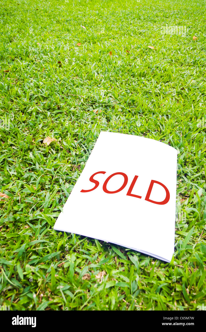 a sold sign on grass field. For real estate background Stock Photo - Alamy