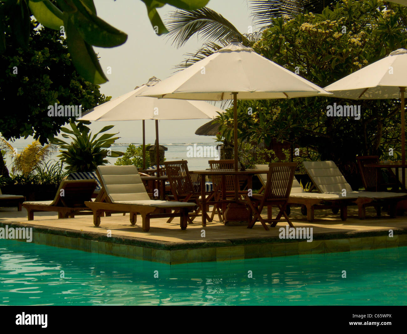 Deserted poolside sun loungers, tables and chairs at Peninsula Beach ...