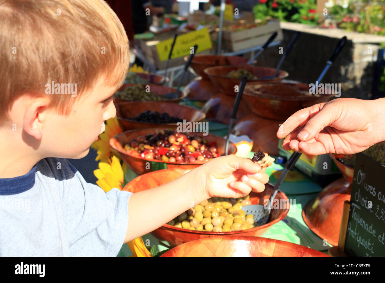 Boy tasting food at market stall at Market at Place d'Eglise, Larmor ...