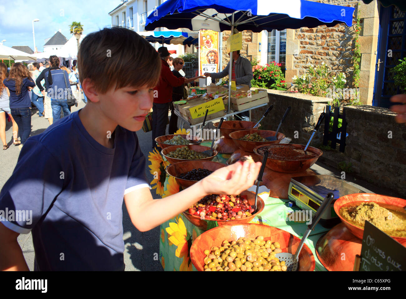 boy tasting food at market stall at Market at Place d'Eglise, Larmor ...