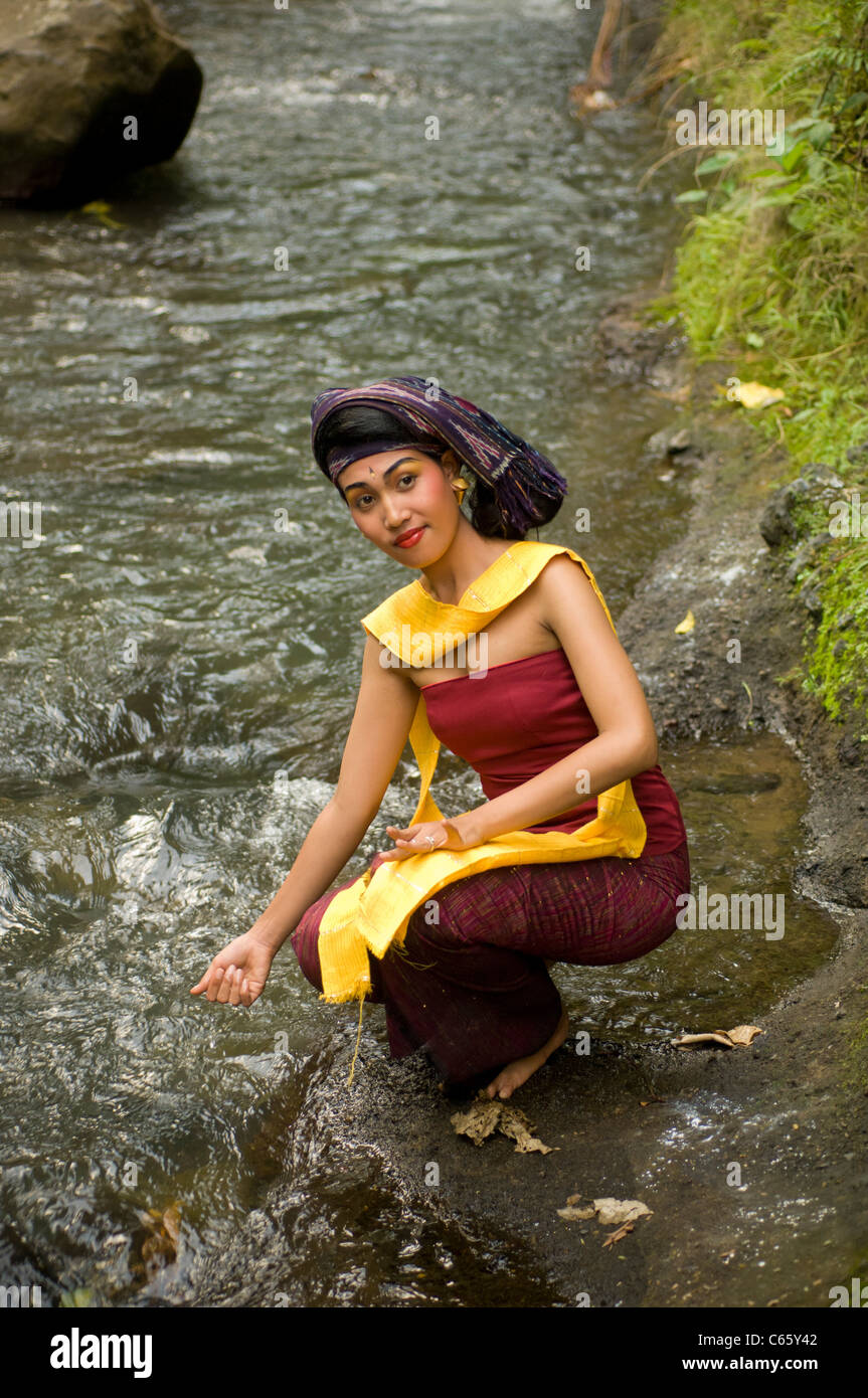 Traditional Balinese dancer outdoors crouching by stream Stock Photo ...