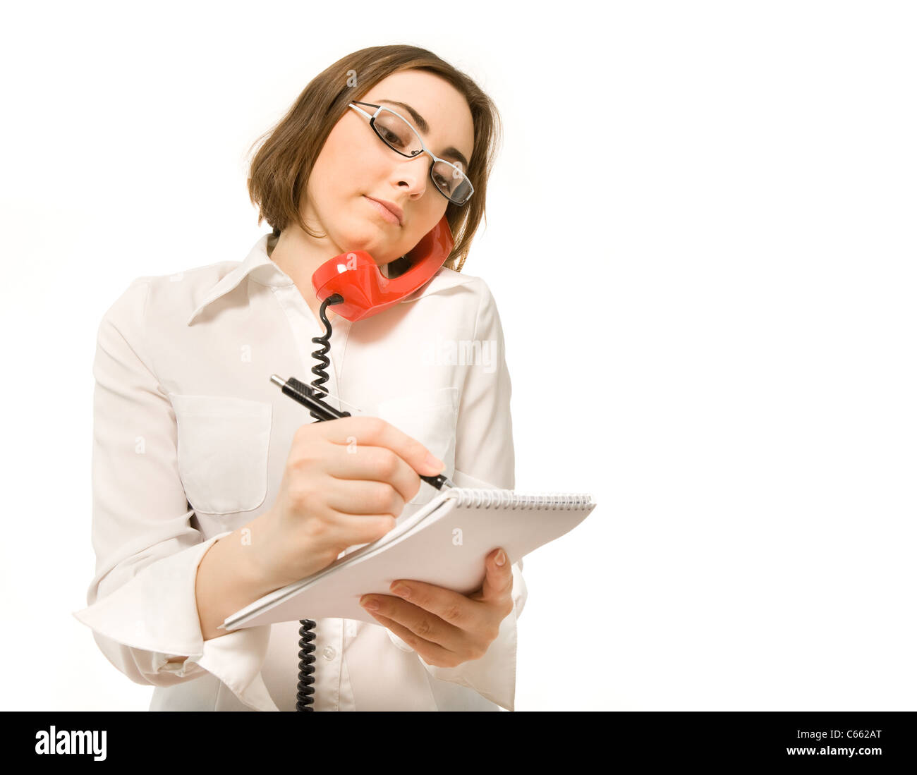 Young secretary making a note while holding a handset Stock Photo - Alamy