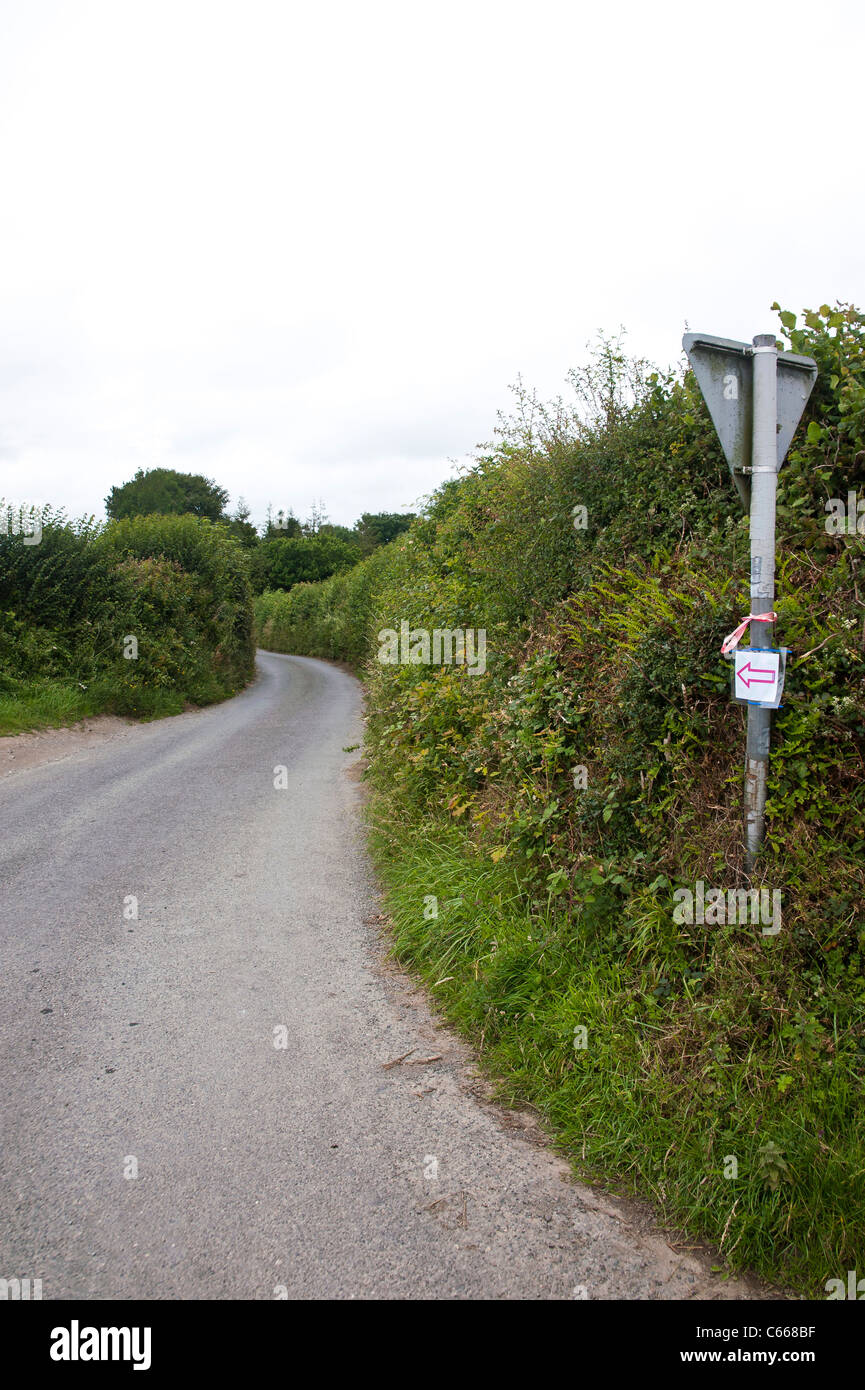 Arrow sign mounted on a street sign support post, directing traffic and ...