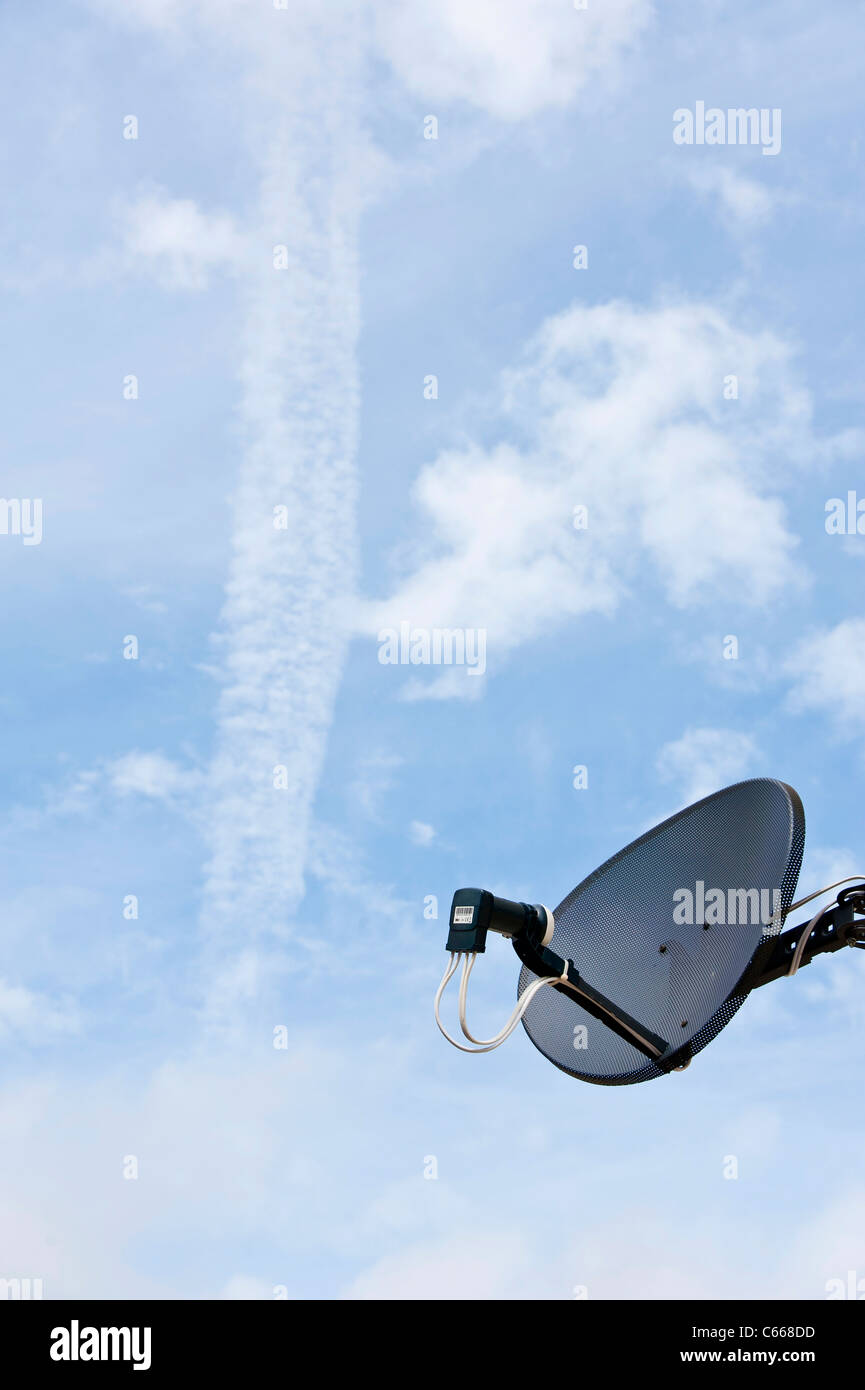 Satellite TV reception aerial (dish) mounted on the wall of a domestic ...