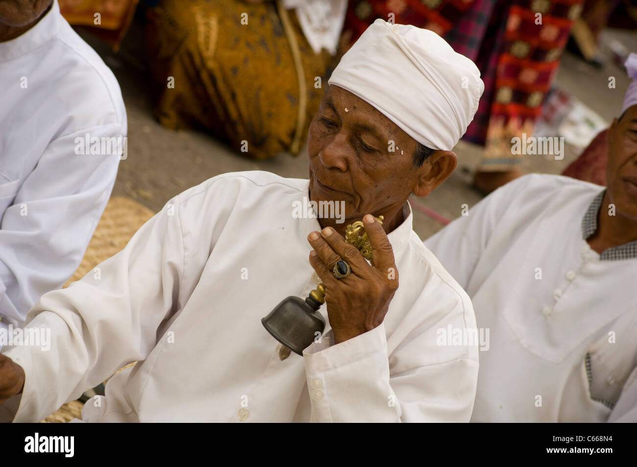 Man holding a small hand bell at Balinese Hindu street festival Stock ...