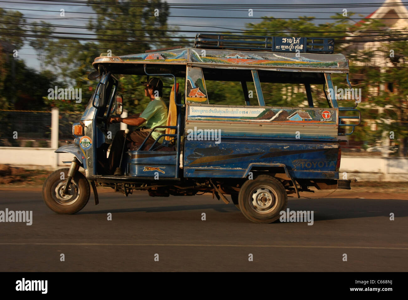 Three wheeler local passenger taxi bus speeds through the streets of ...
