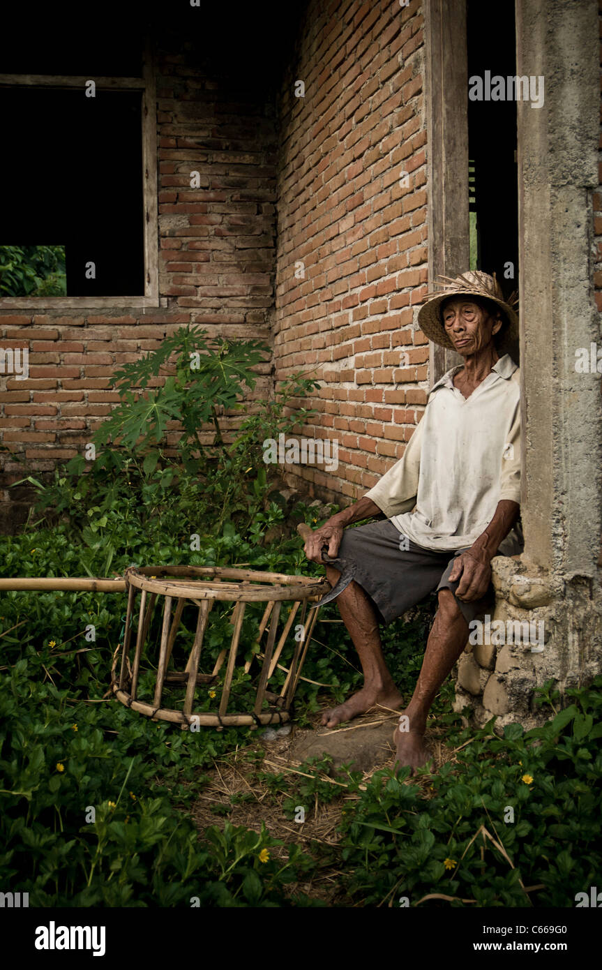 Balinese farmer and weaver in a derelict farm building Stock Photo - Alamy