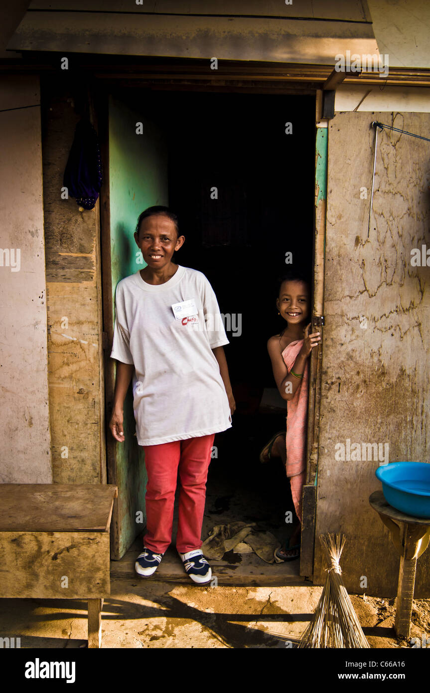 Smiling Balinese woman and her daughter standing in the doorway of her ...