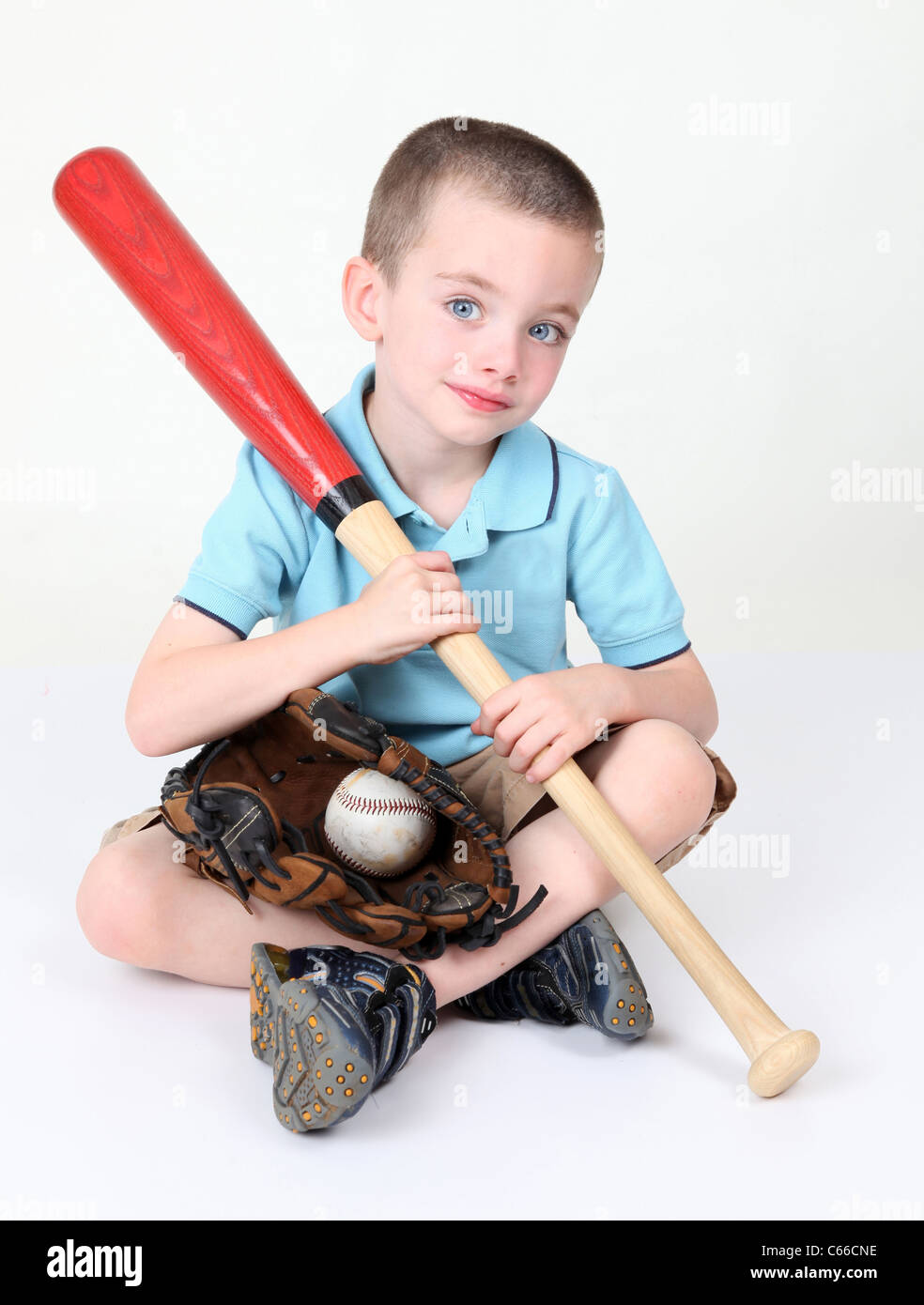Preschool boy sitting down holding bat in studio Stock Photo - Alamy