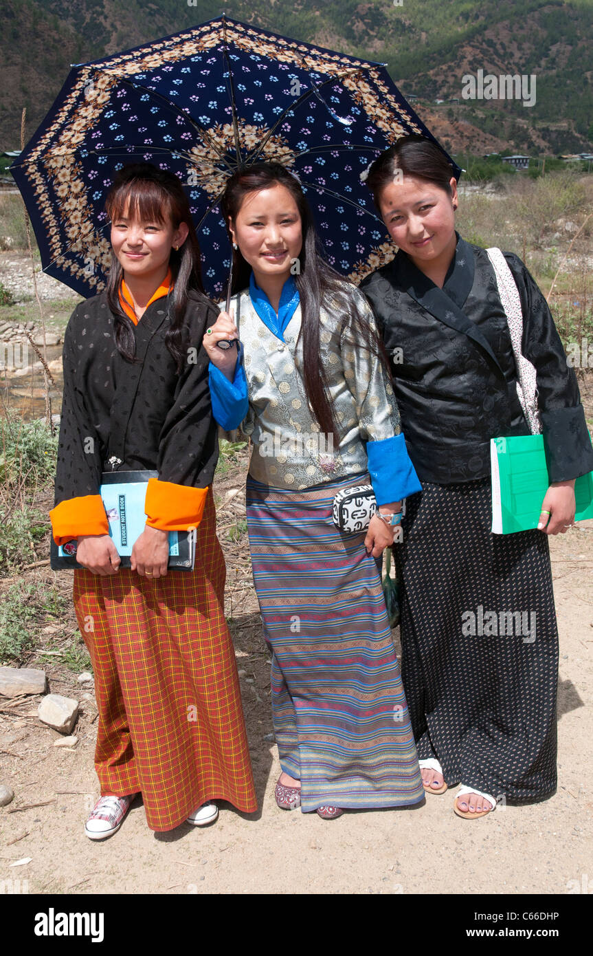 Three female teenagers pausing with umbrella. paro valley. Bhutan Stock ...
