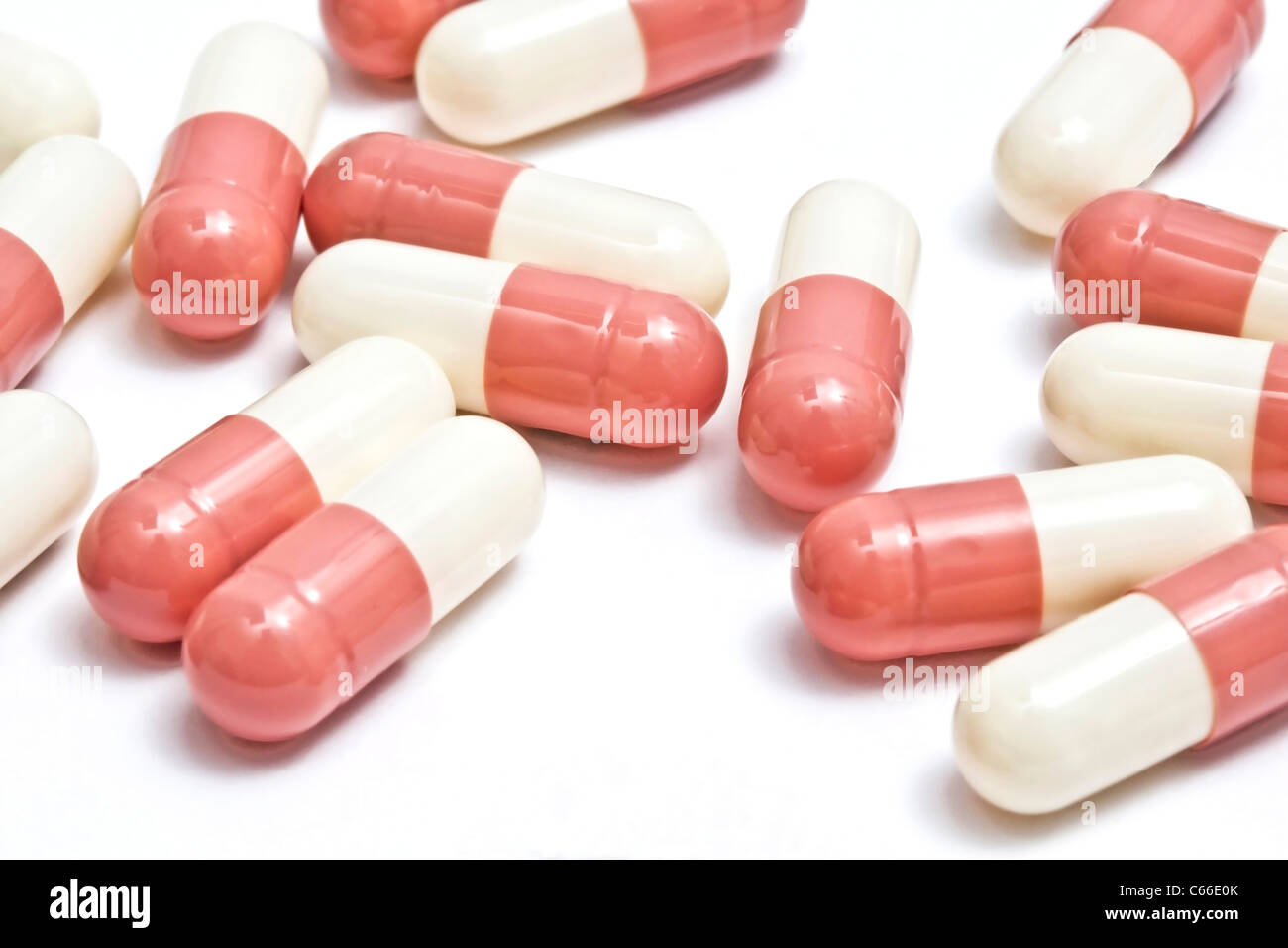 Pink capsules isolated on white background Stock Photo - Alamy
