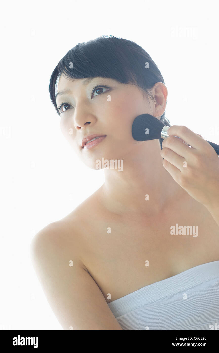 Woman Putting on Powder on Cheek Stock Photo - Alamy